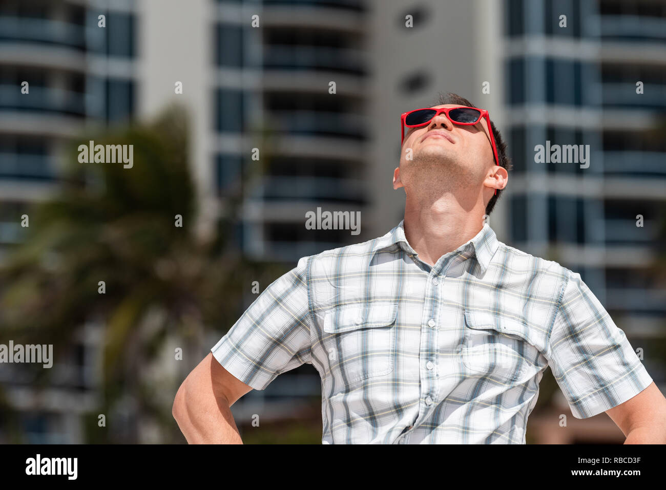 Young man looking up closeup on beach during sunny day with in Miami ...