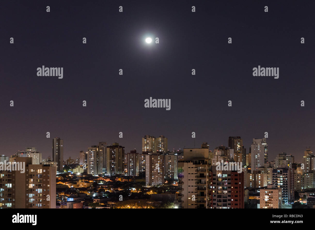 City night view with moonlight and buildings iluminated in a ...