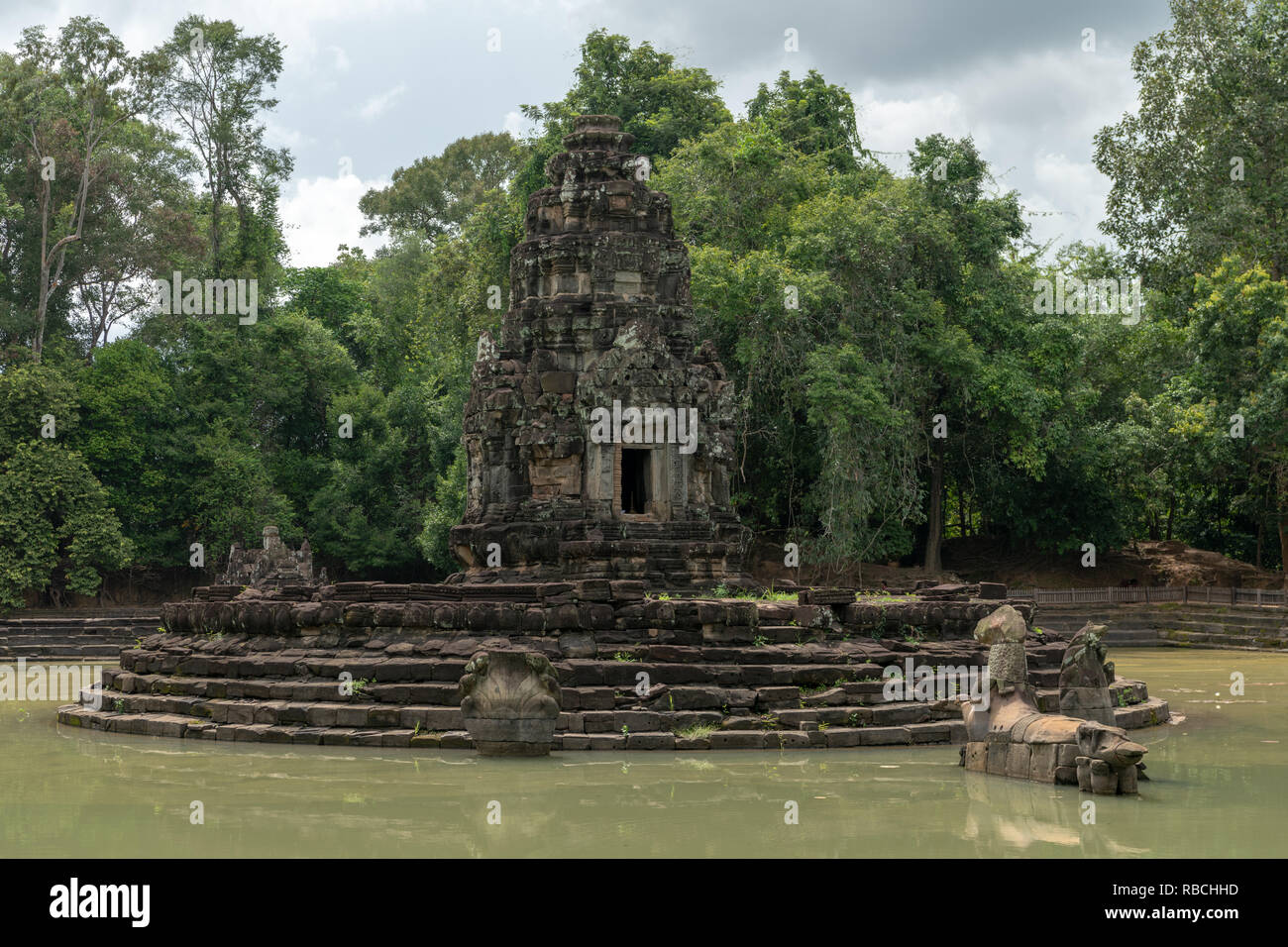 Circular stone monument with doorway in pond Stock Photo - Alamy