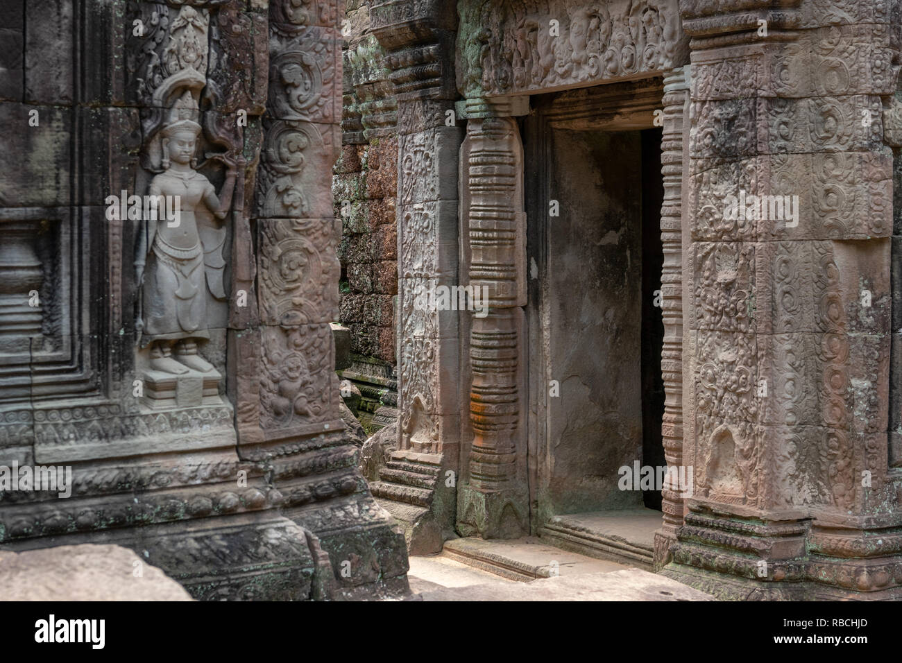 Decorated stone entrance to temple opposite statue Stock Photo - Alamy