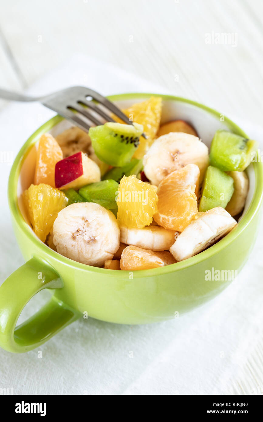Close-up green mug with fresh fruit salad on white background Stock ...