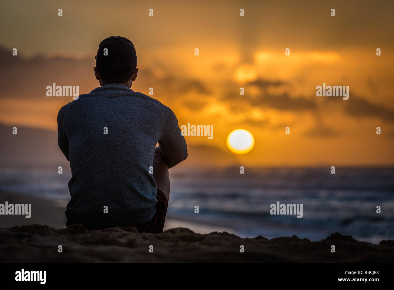 Man sitting beach watching waves hi-res stock photography and images ...