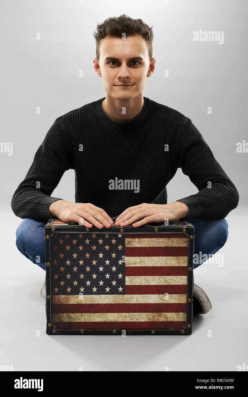 Young american with a hand case on gray background Stock Photo - Alamy