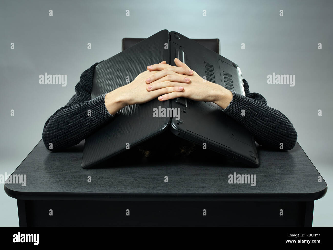 Overworked student pulling a laptop over his head on the desk Stock ...