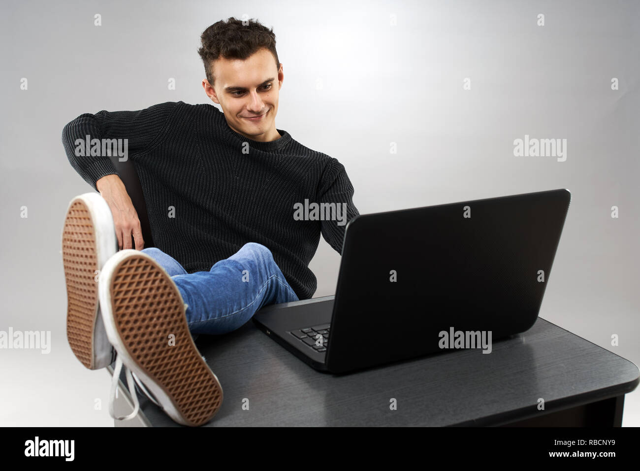 Happy student putting his feet up after homework Stock Photo - Alamy