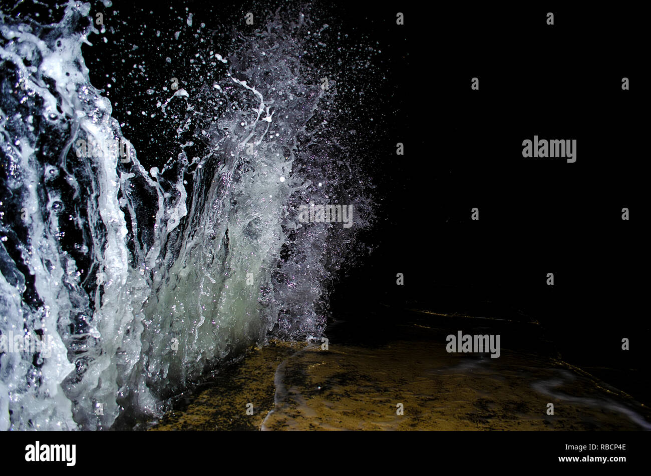 Splashing wave on the Black sea in the night Stock Photo - Alamy