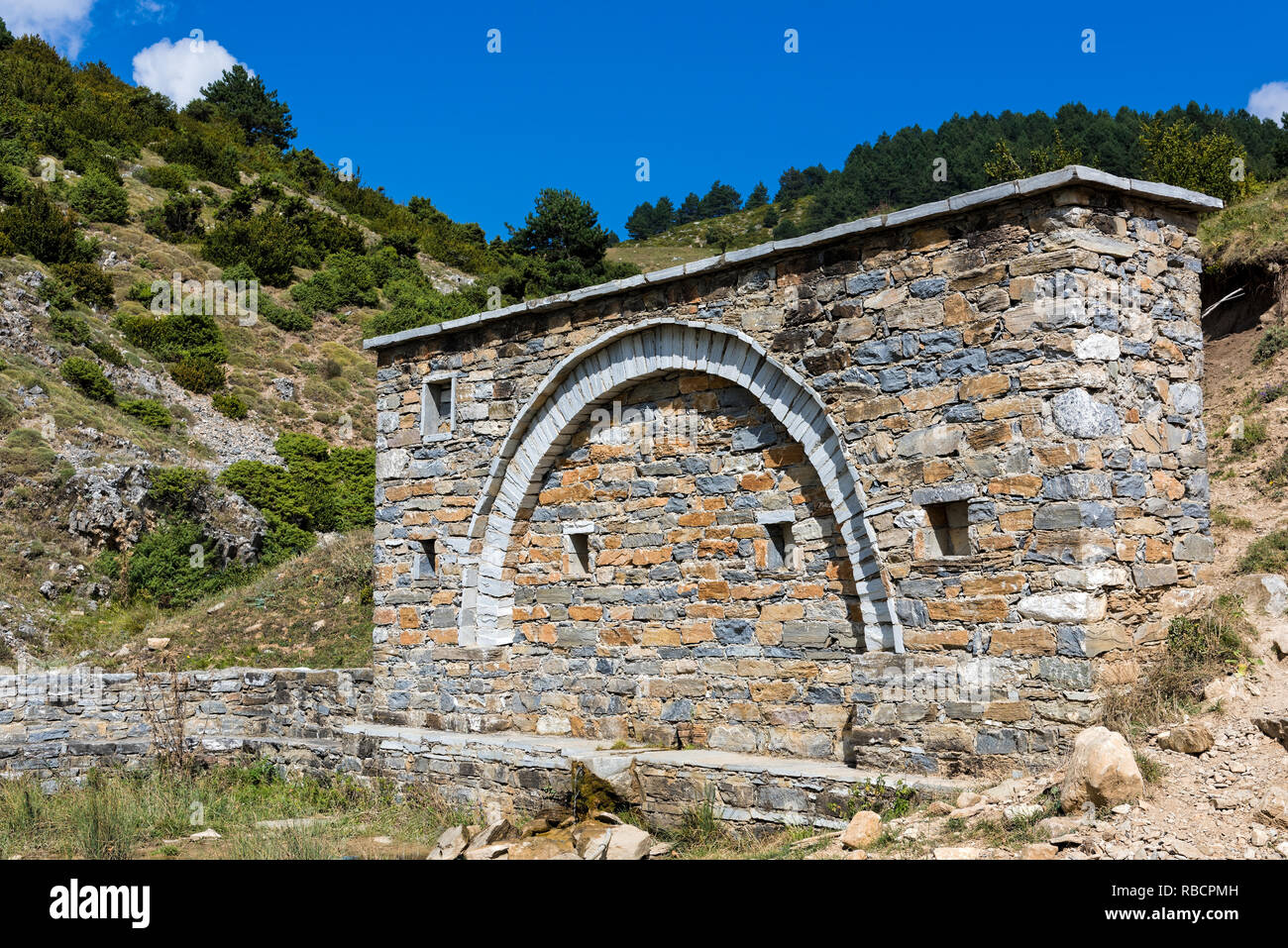 Traditional stone drinking fountain in the village of Kokkinopilos on ...