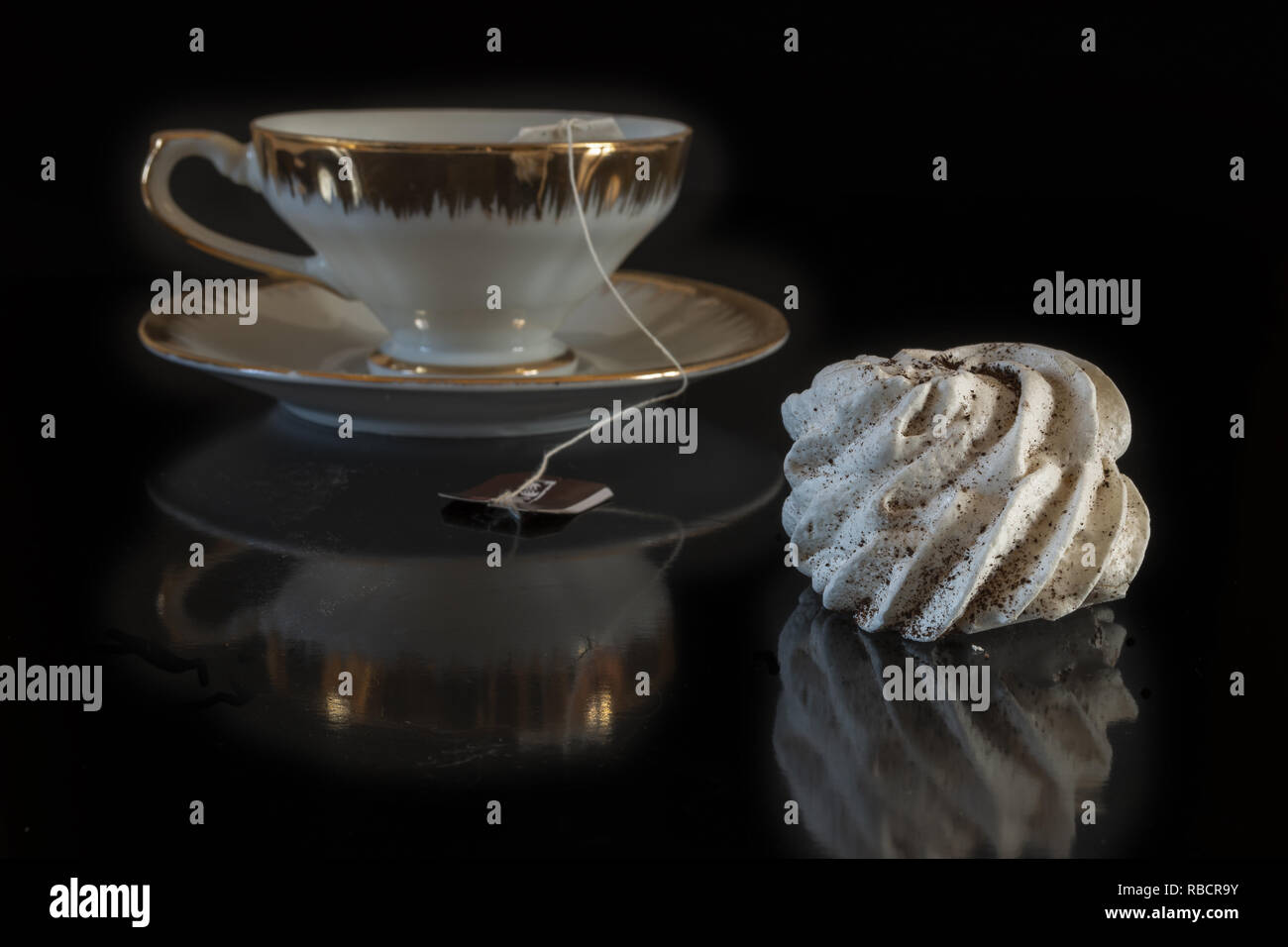 teacup with sachet and biscotto meringue black background Stock Photo ...