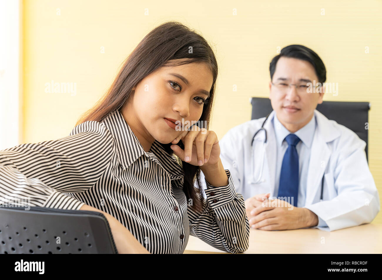 Portrait of Young adult female Patient with background of doctor in ...