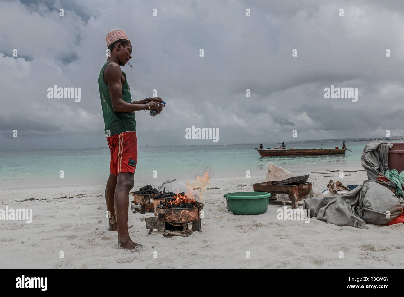 A fisherman seen making fire by the beach in stone town Zanzibar Stock ...