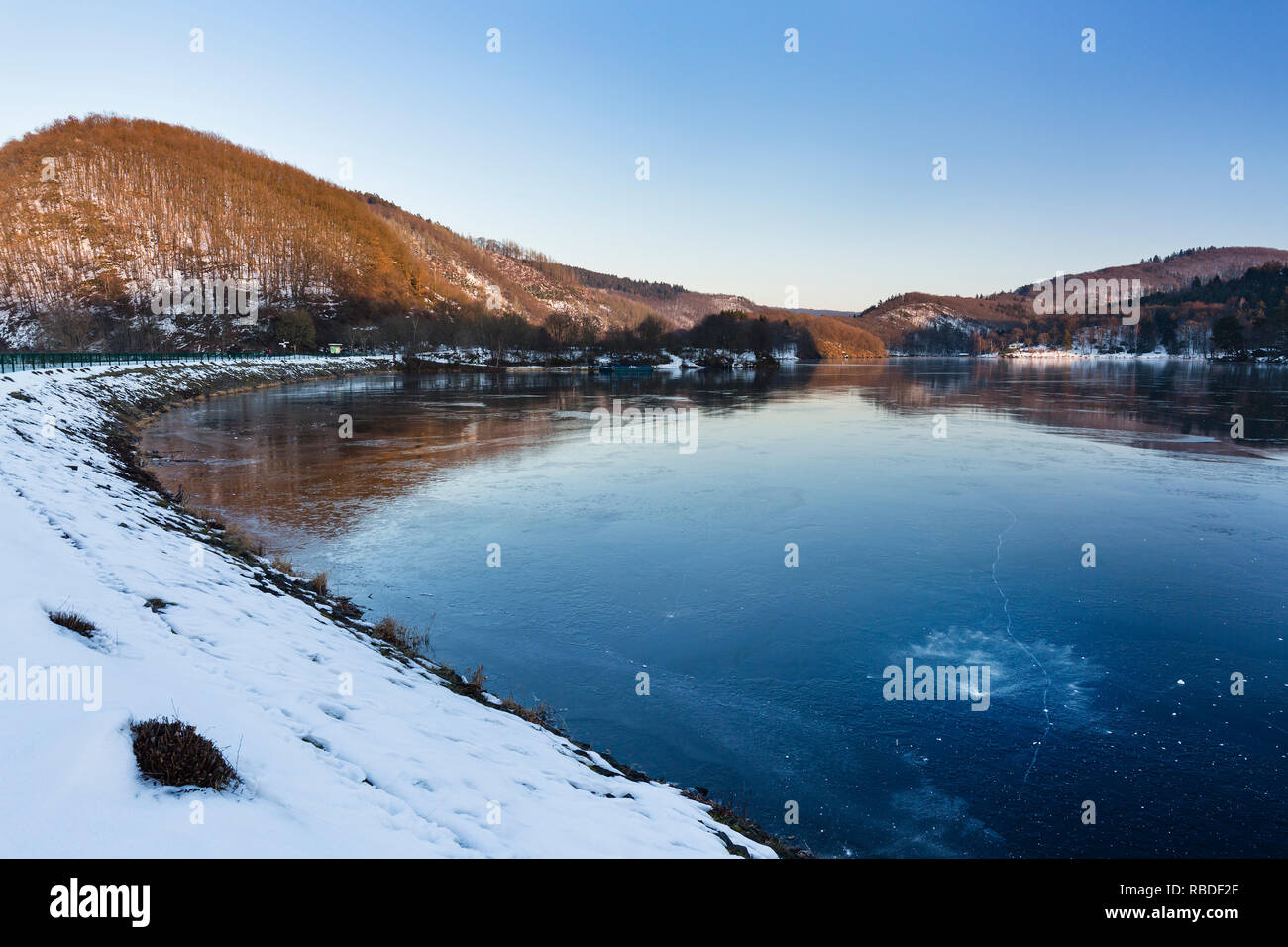 Evening view over the frozen Obersee of lake Rursee near the village of ...