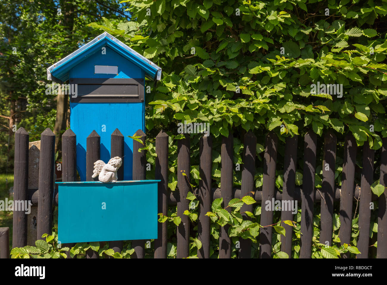 Blue mailbox with angel figure on a fence Stock Photo - Alamy