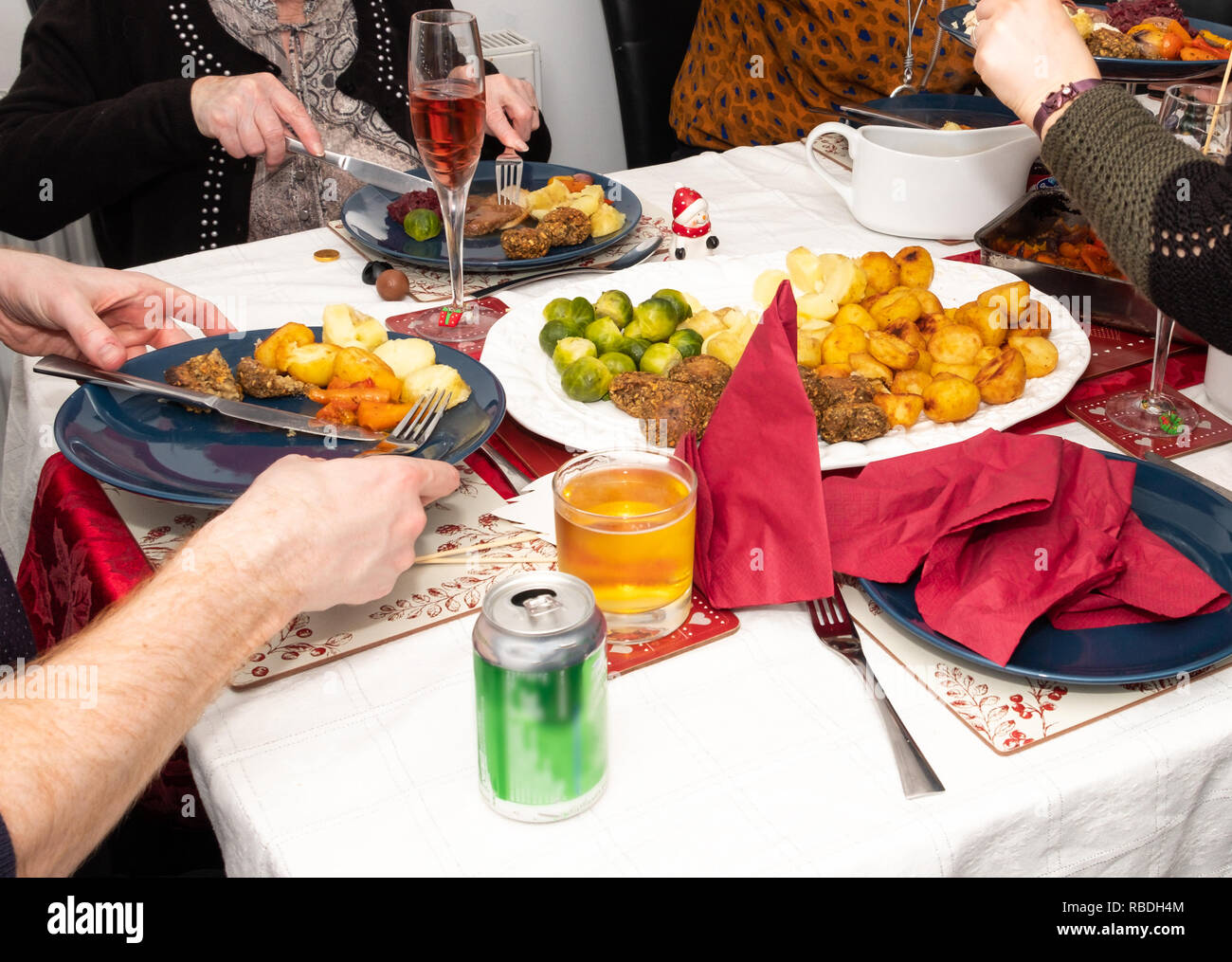 A very busy Christmas Table with all the family digging in Stock Photo ...