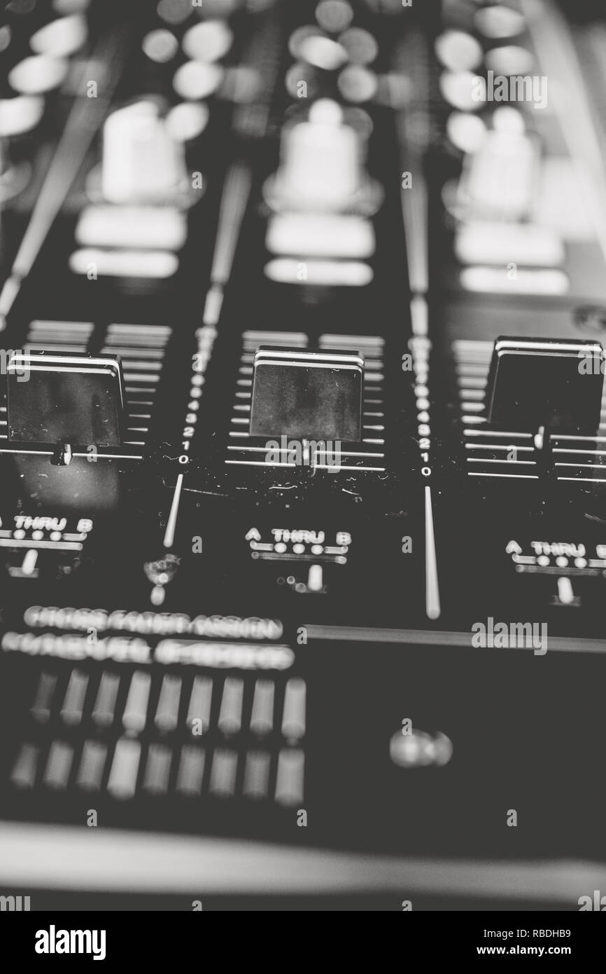 An artistic close up of a DJ's mixer / mix desk in black and white ...