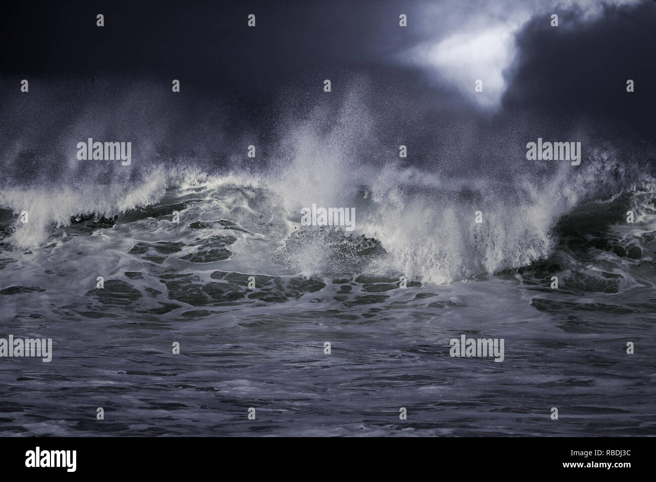 Ocean wave spray made by wind in the Portuguese coast. Enhanced sky ...