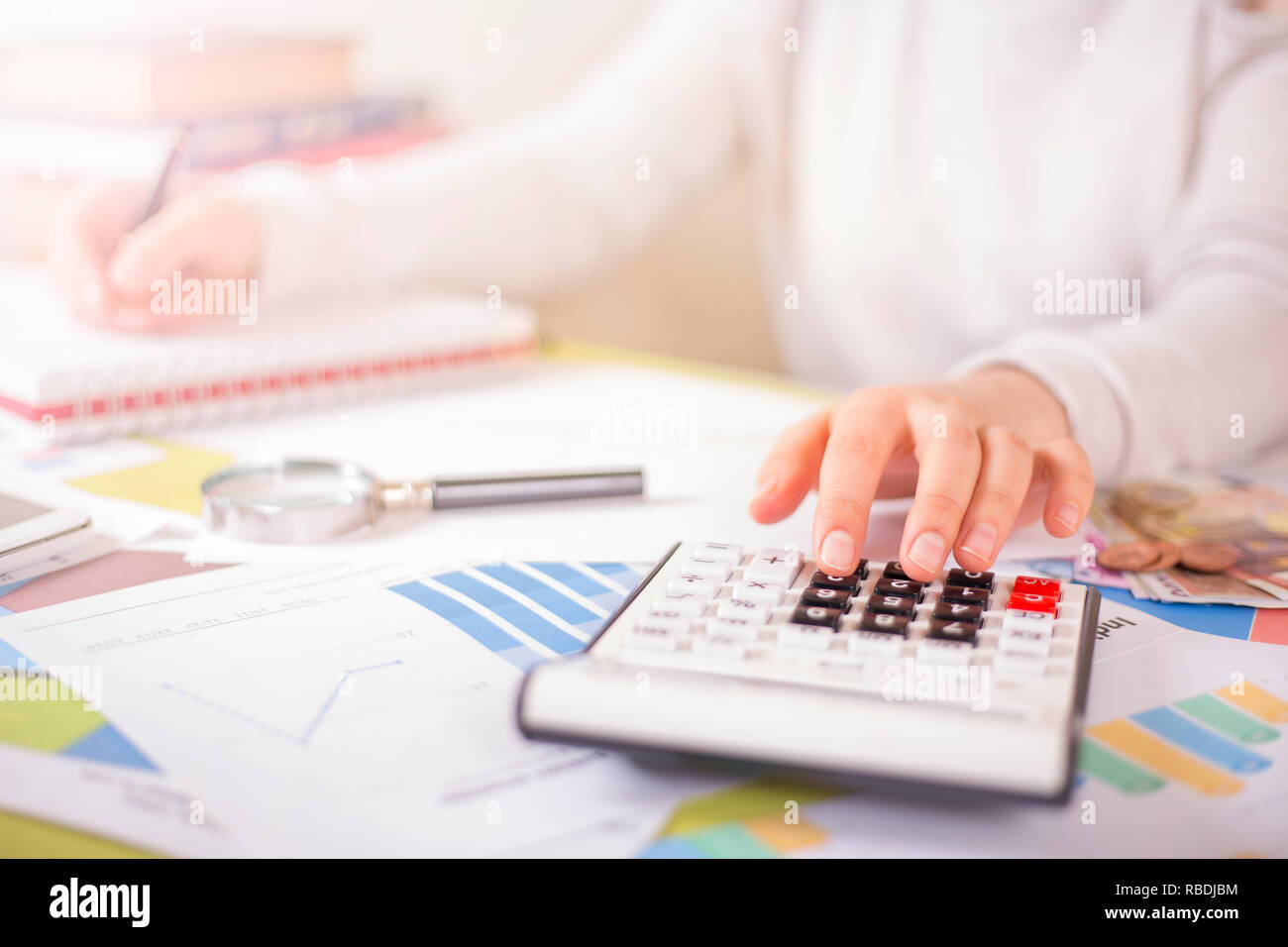 woman is doing calculations on office desk Stock Photo - Alamy