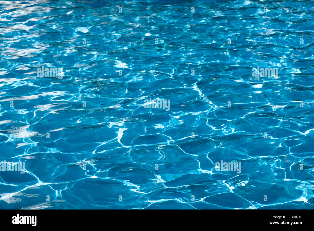 Blue and bright ripple clean water surface in swimming pool with sun ...