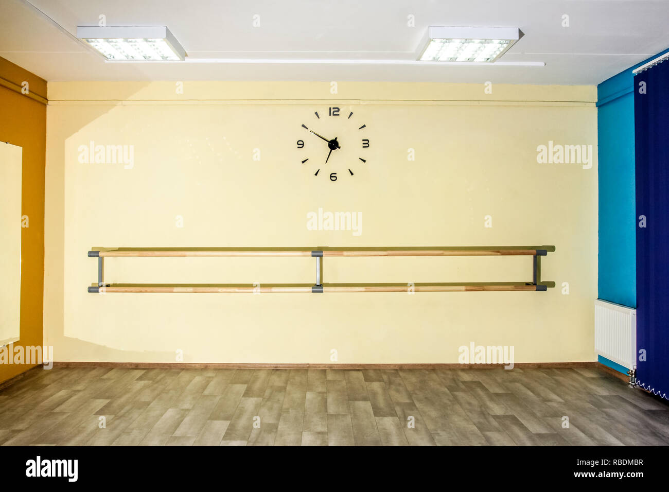 empty hall dance hall with clock on the wall and ballet bench for ...