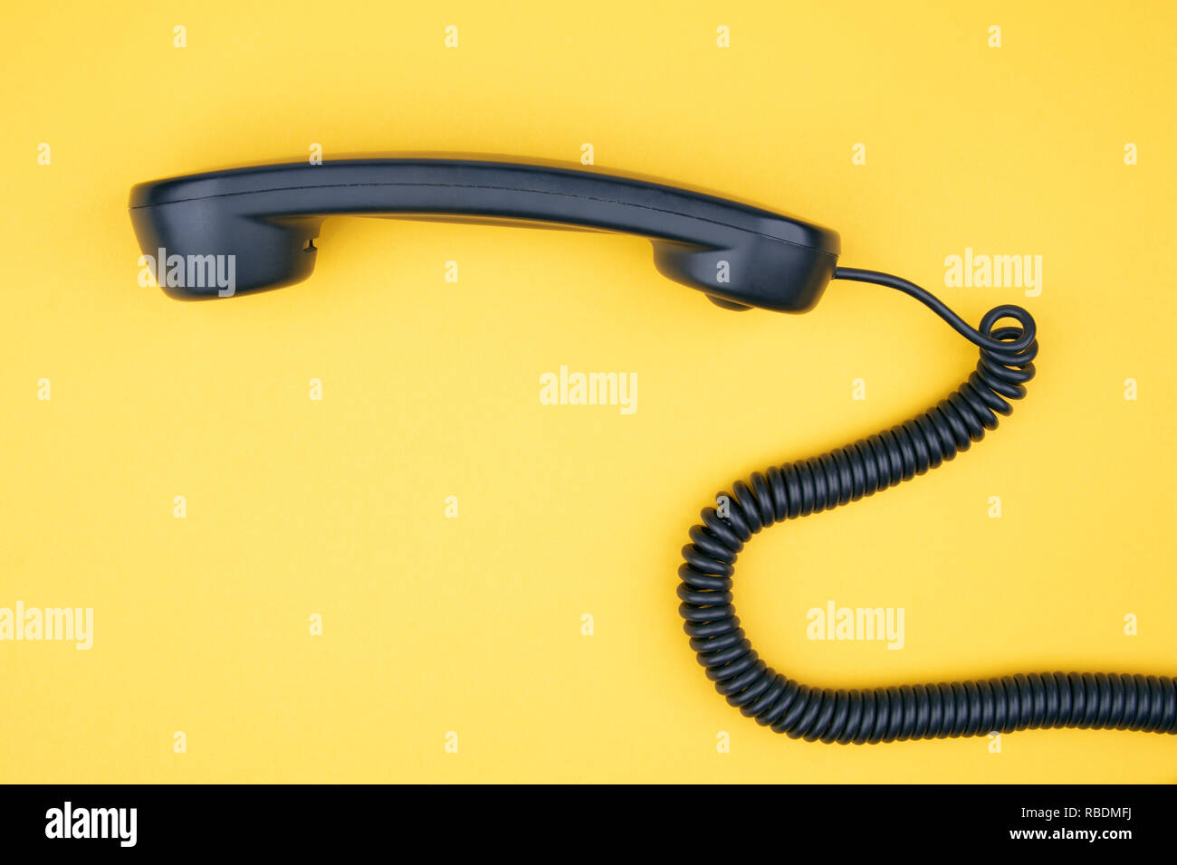 Black Phone Receiver on yellow Background Stock Photo - Alamy