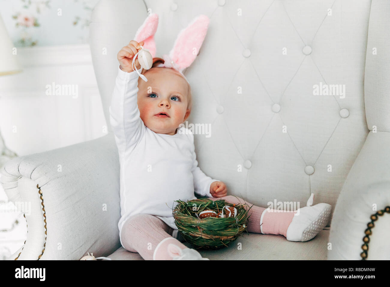 Little child girl wearing bunny ears on Easter day. Girl holding basket ...