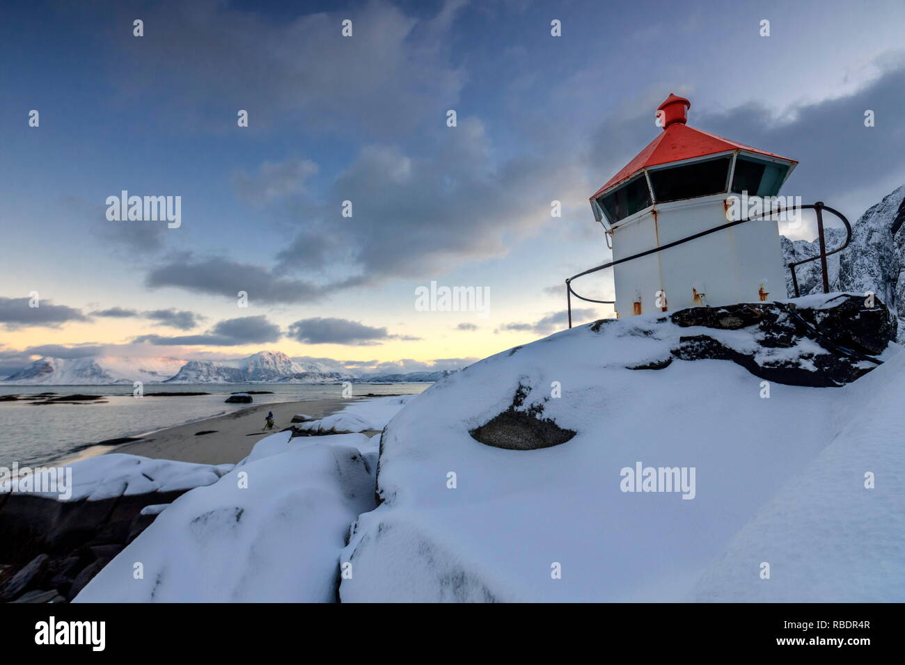The blue arctic dusk on the lighthouse surrounded by snow and icy sand ...