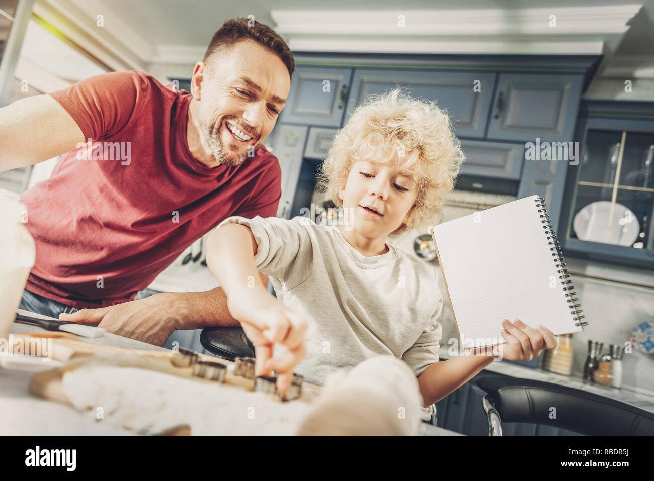 Right proportion. Low angle of creative appealing boy using cookie ...