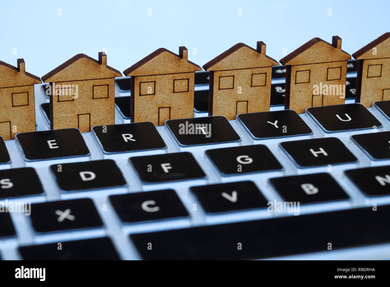 A computer keyboard with a row of small wooden houses Stock Photo - Alamy
