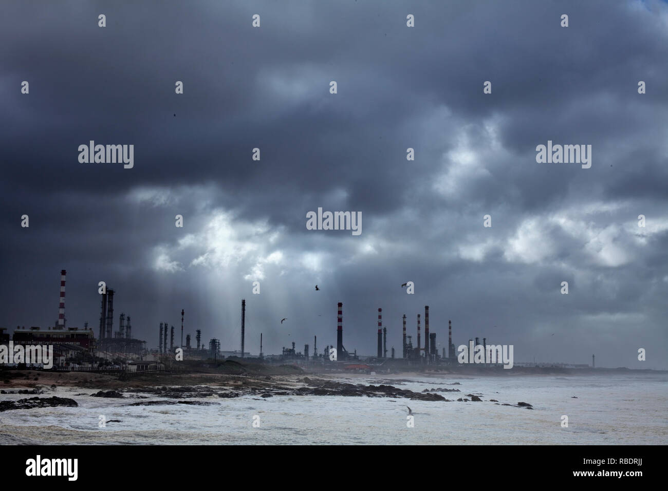 Big oil refinery by the sea against dramatic sky before heavy storm ...