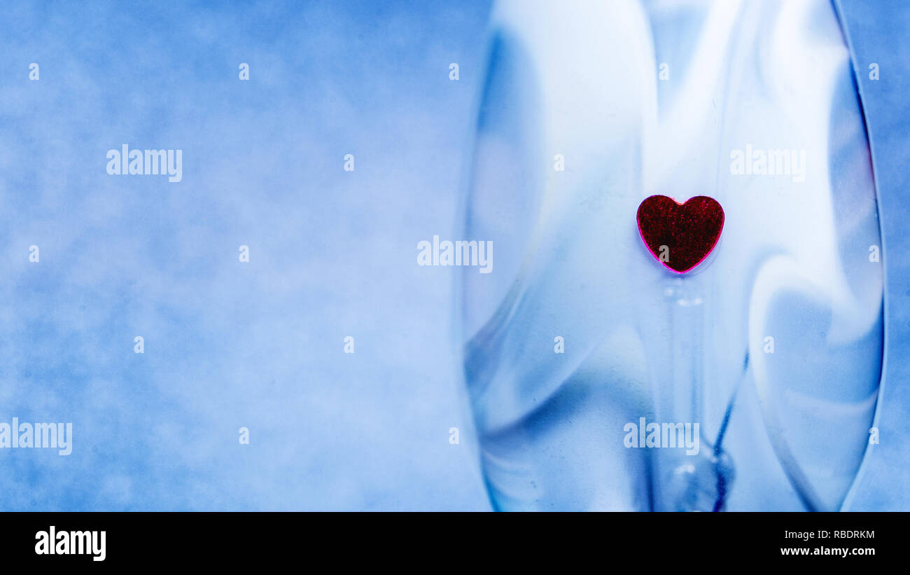 Plain blue background with little red heart Stock Photo - Alamy