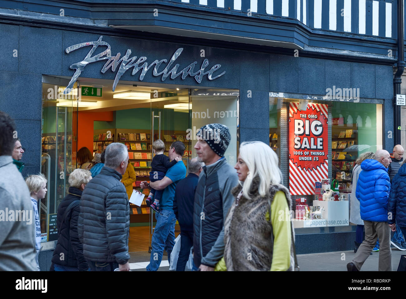 Shoppers walking past the Chester branch of Paperchase with sale signs ...