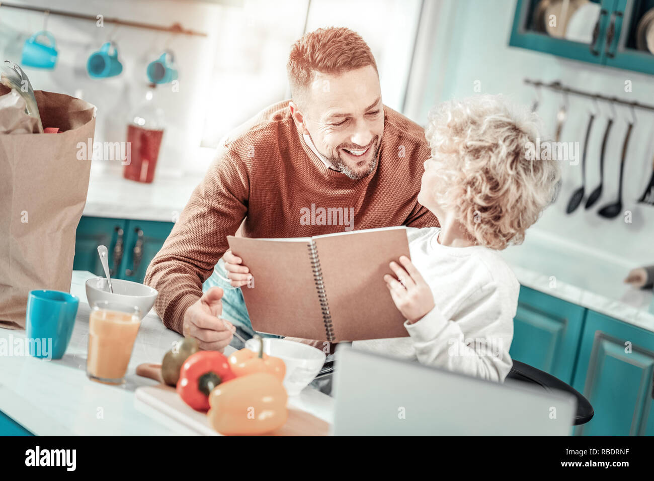 Home interaction. Joyful male person keeping smile on face while being ...
