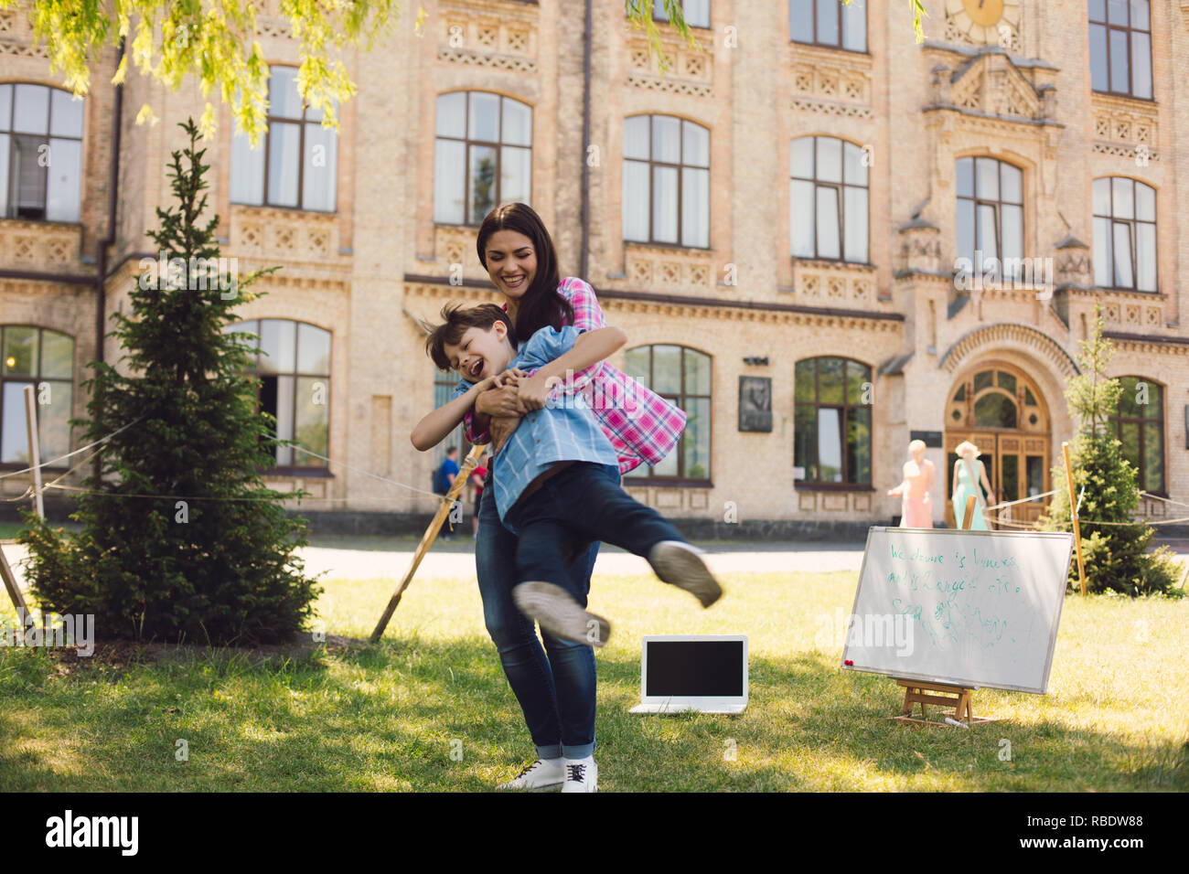 Teacher play with kid outside Stock Photo - Alamy