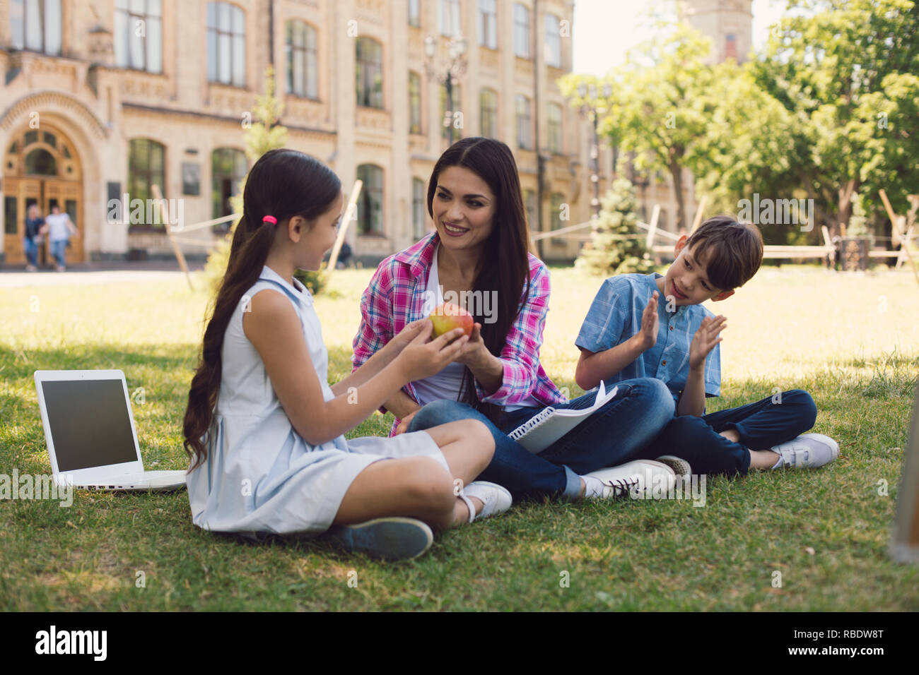 Teacher giving apple to kid Stock Photo - Alamy