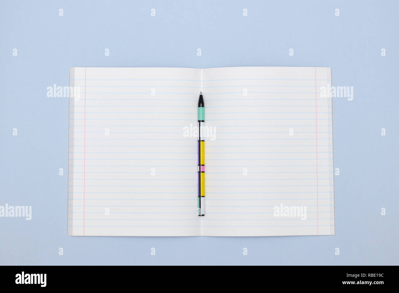 open school notebook with pen on blue background. a clean, white sheet ...