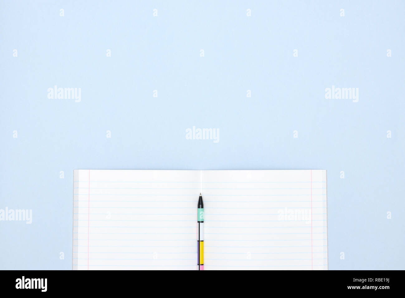 open school notebook with pen on blue background. a clean, white sheet ...
