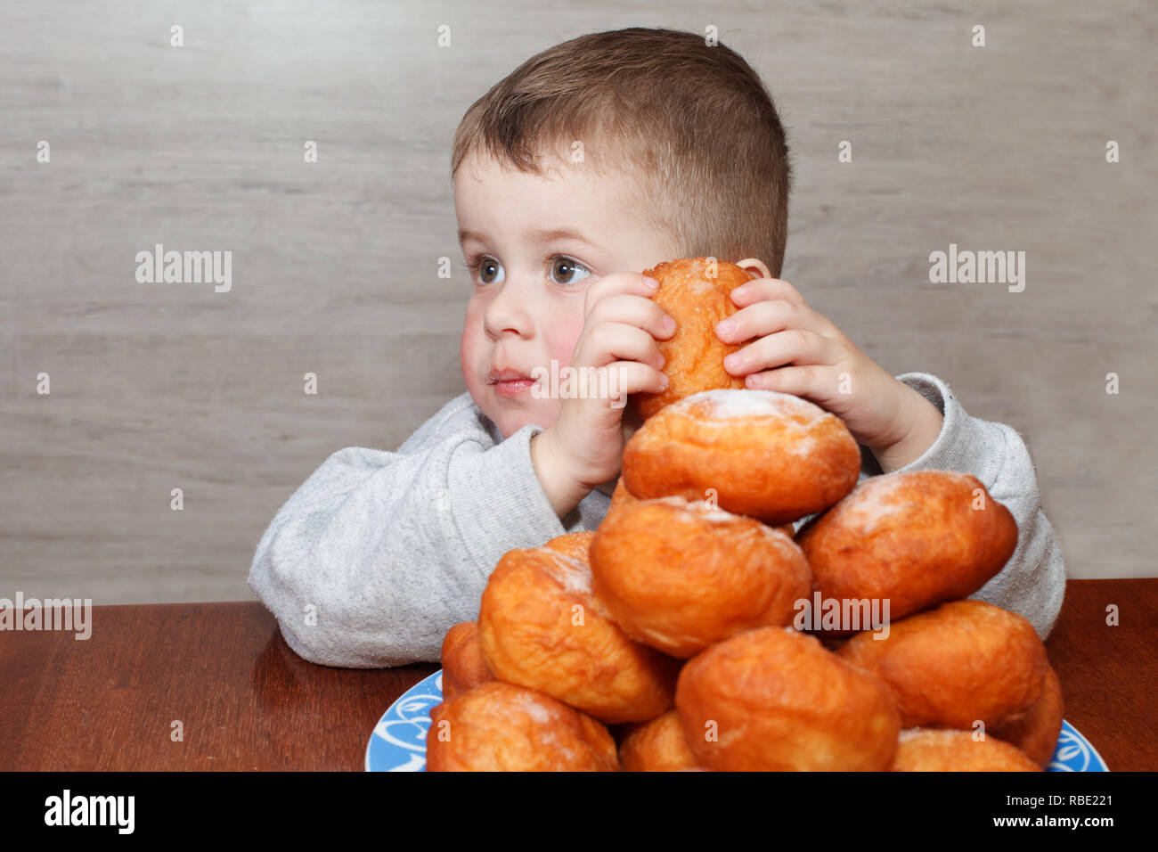 Little boy eating a donut. Bright kid Stock Photo - Alamy