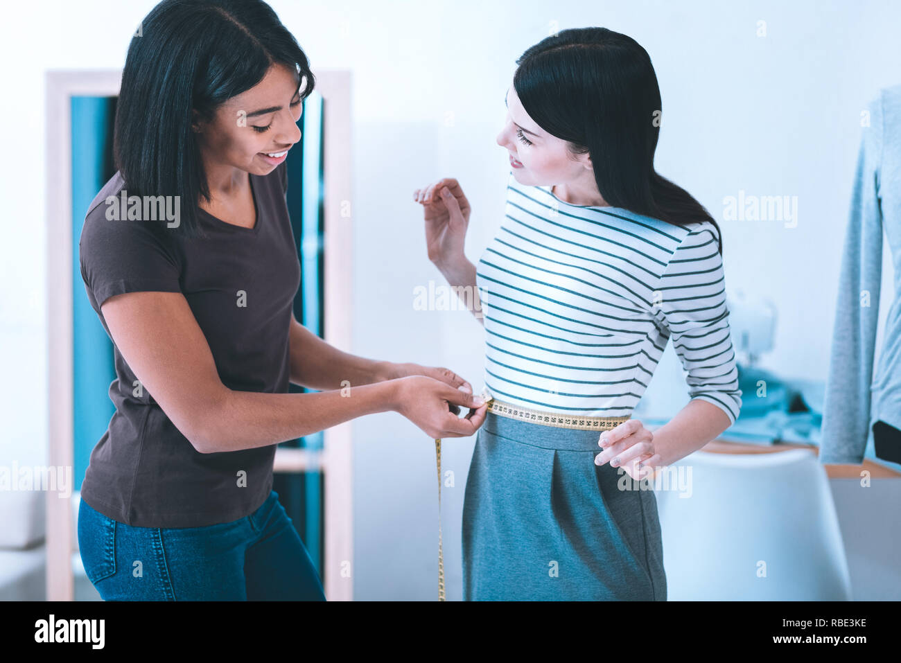 Preparations. Creative young designer measuring models waist sewing ...