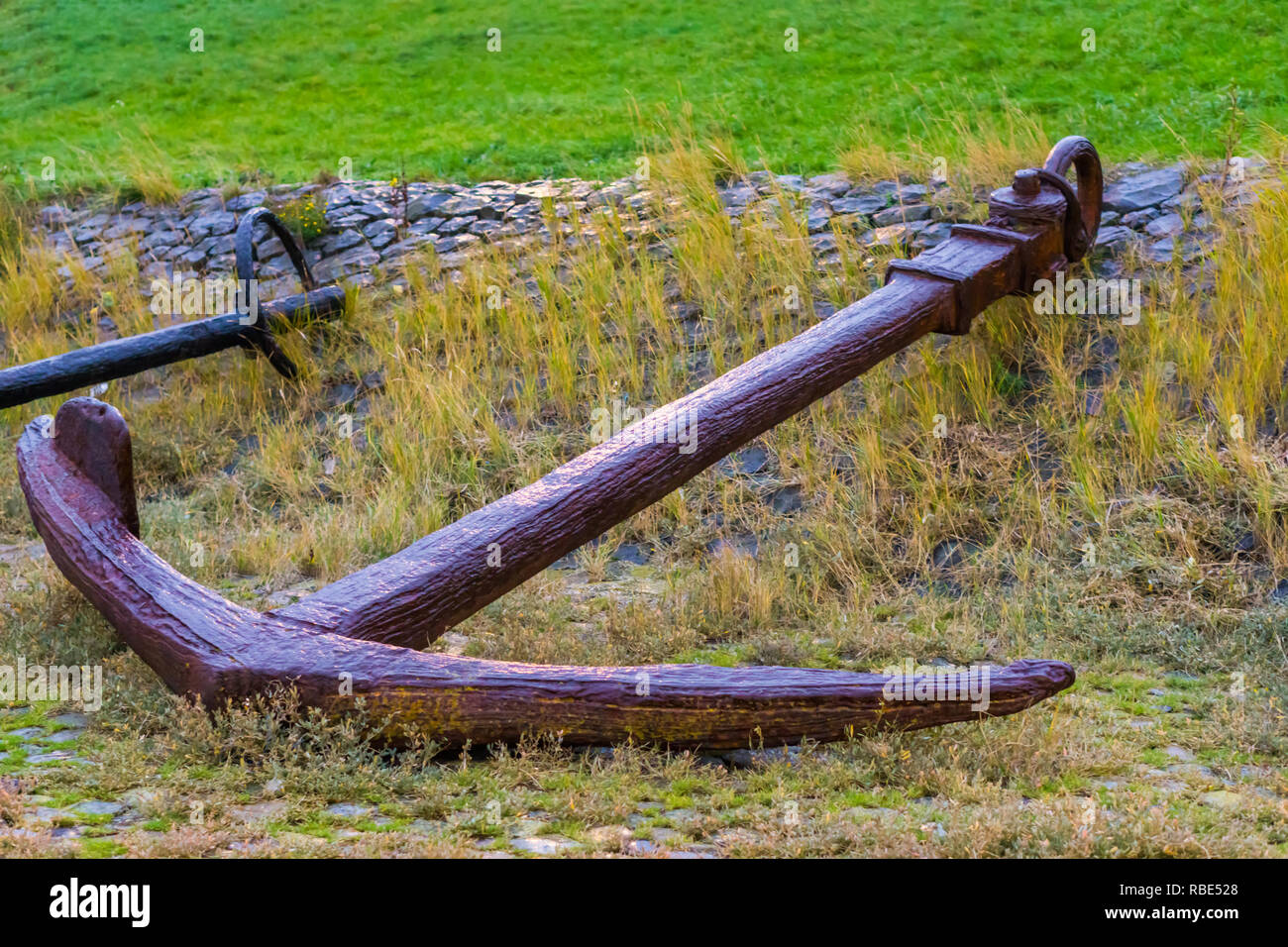 Big old rusty pirate ship anchor laying on the ground, harbor ...