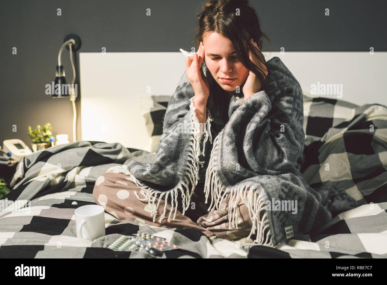 Subject disease and treatment. young Caucasian woman sits home bedroom ...