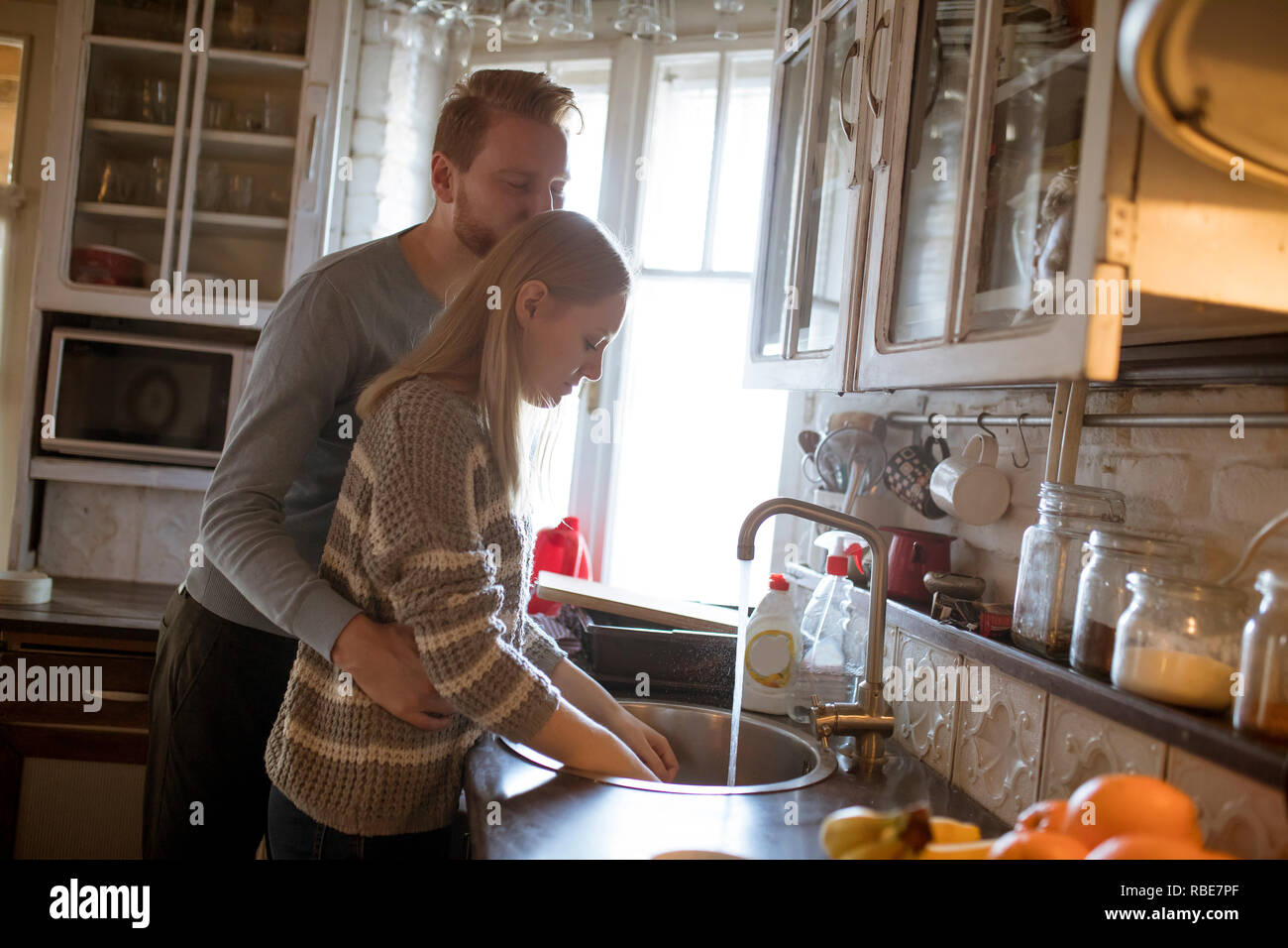 Young happy couple in love washing dishes in the kitchen Stock Photo ...