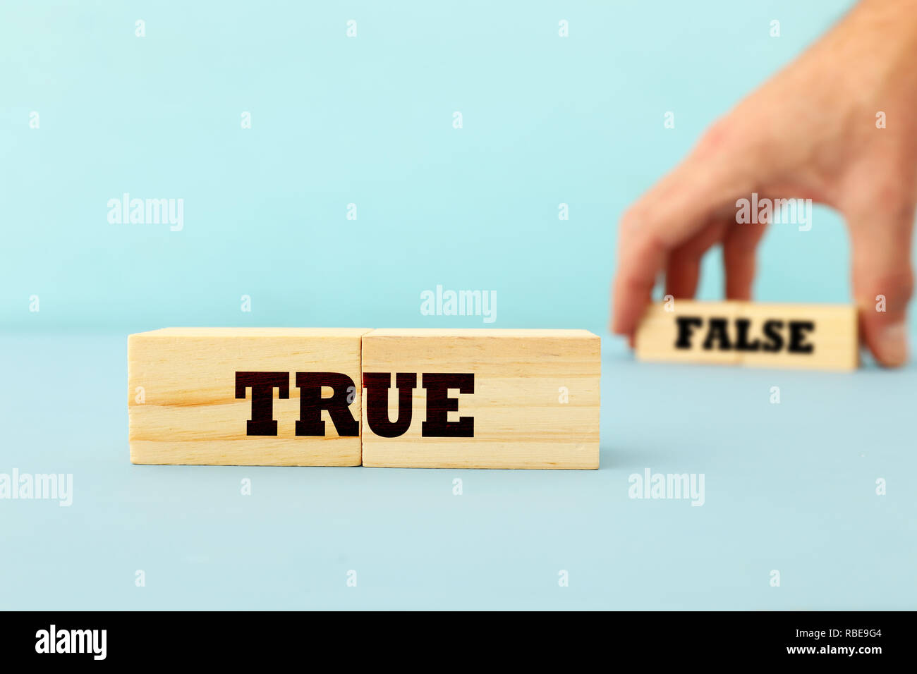 true or false concept man hand picking wooden cubes with text over ...