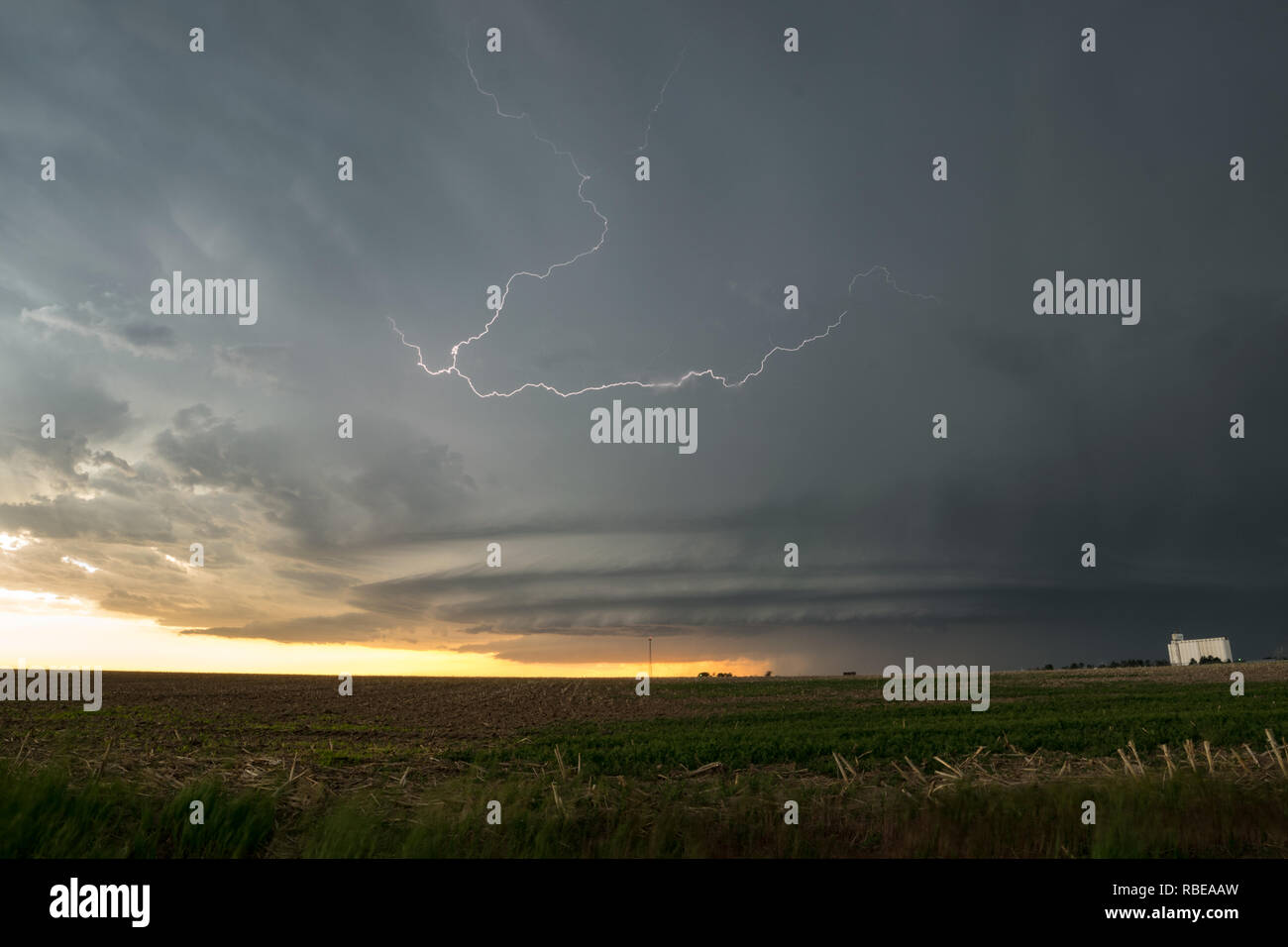 Supercell, a rotating thunderstorm, at sunset with lightning bolt over ...