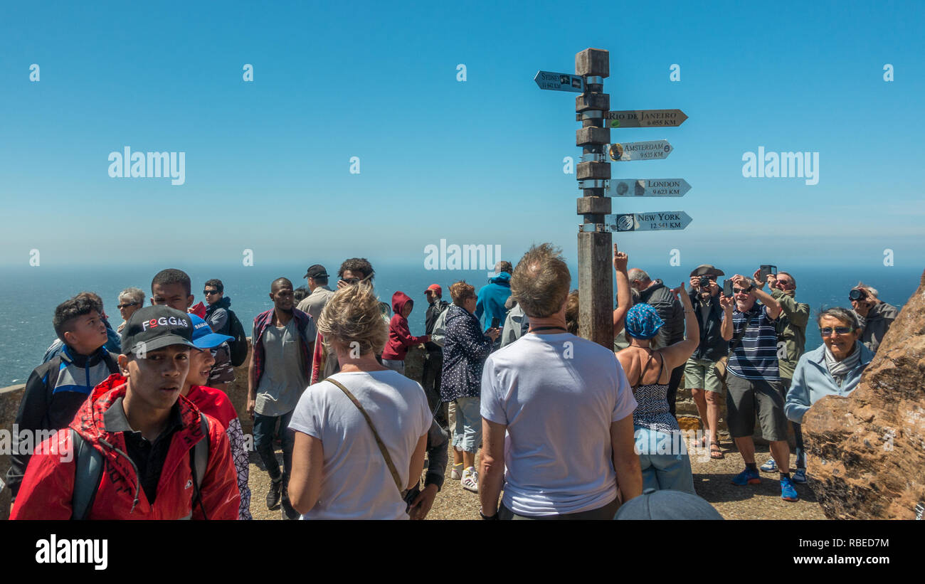 Tourists taking photos of themselves of an international signpost at ...