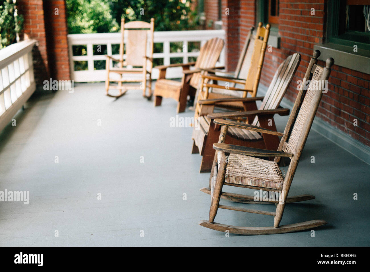 5 rocking chairs empty sitting on porch Stock Photo - Alamy