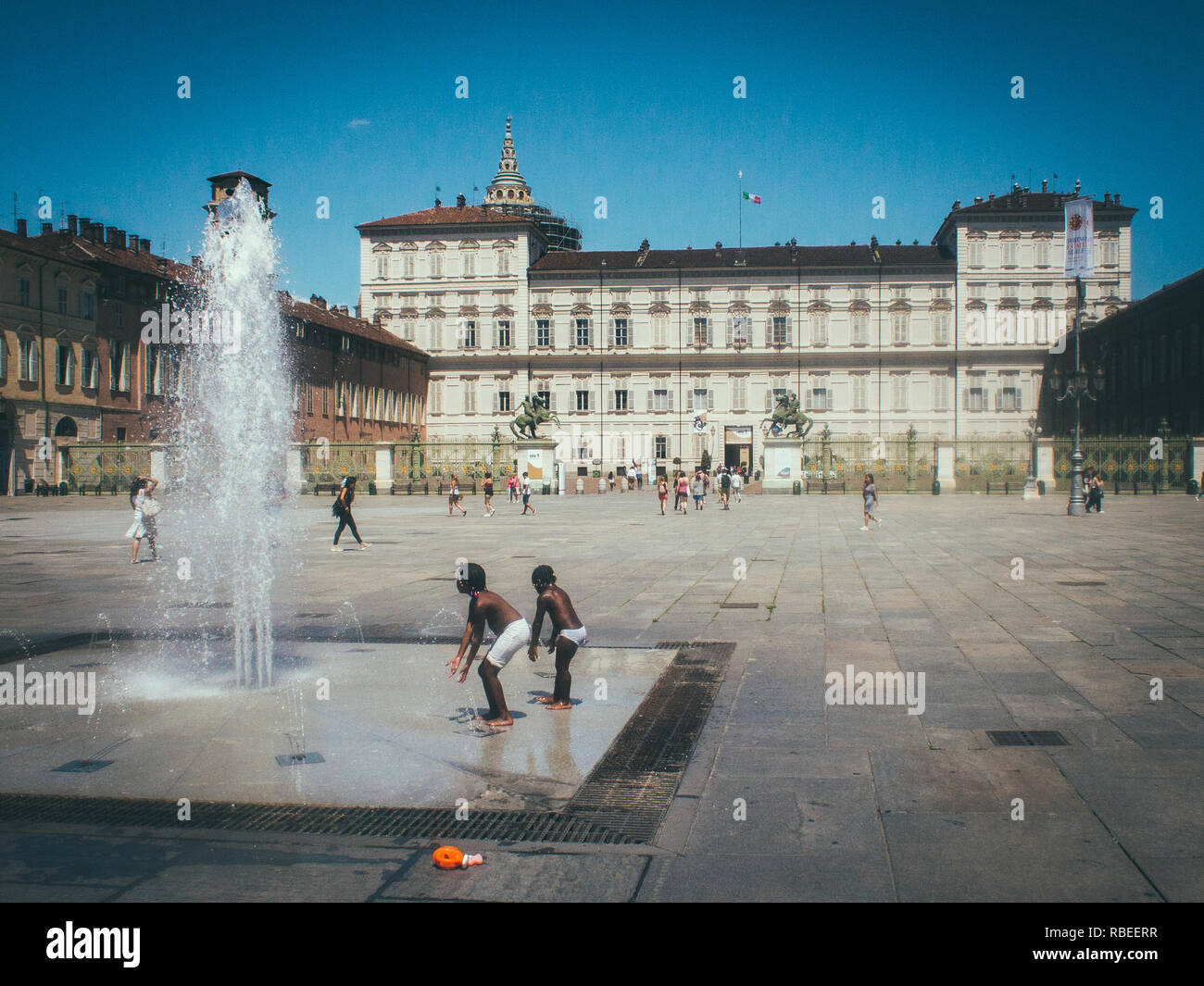 Kids playing in the fountain on a hot day in front of The Royal Palace ...