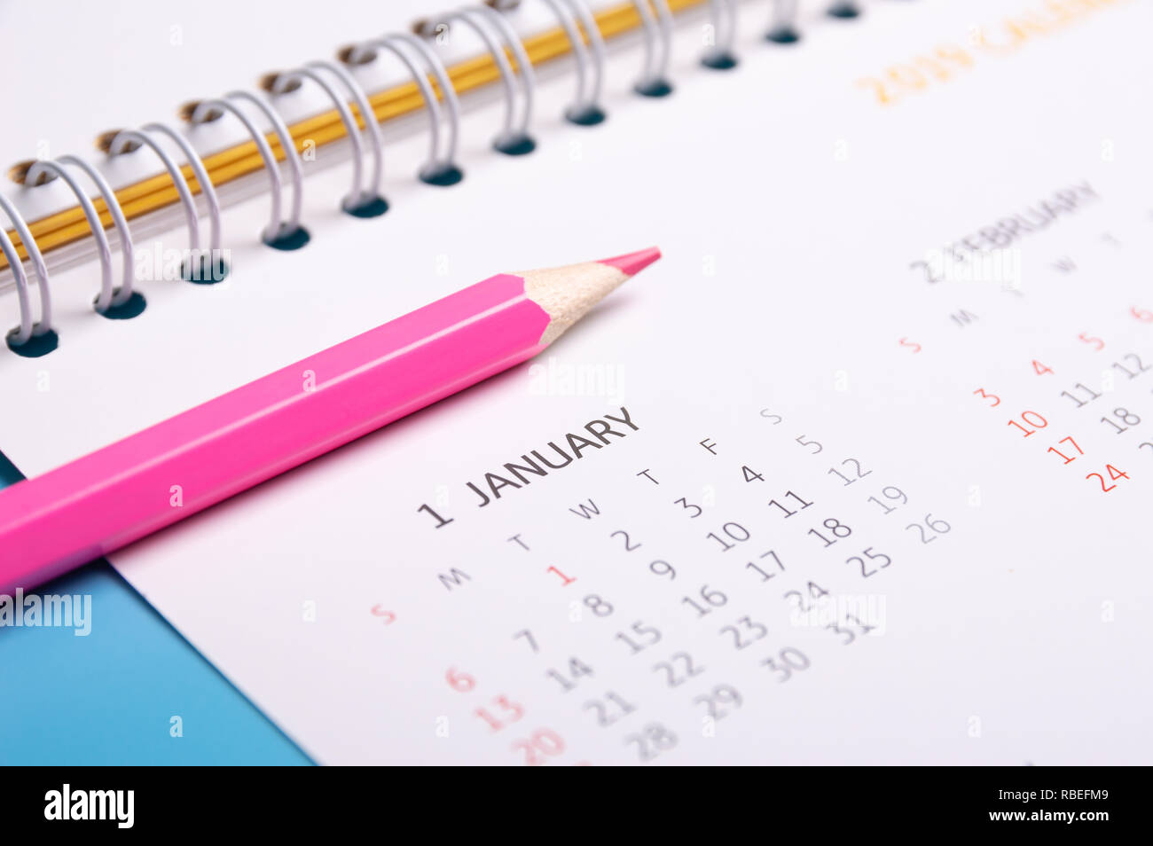 red pencil and calendar on blue background Stock Photo - Alamy