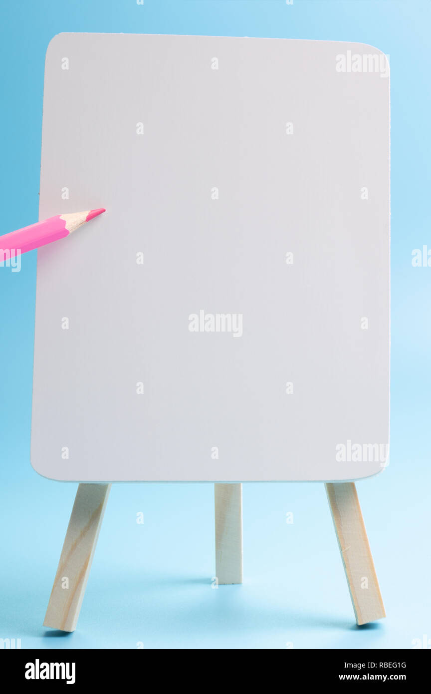 red color pencil floating white easel front blue background Stock Photo ...