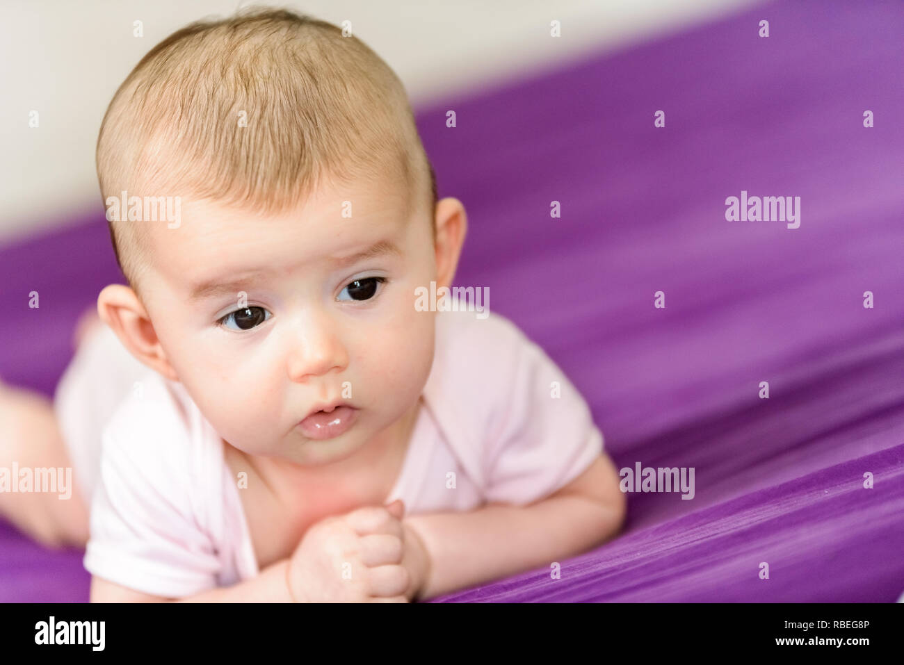 Newborn baby with adorable face, calm and relaxed lying on his bed ...