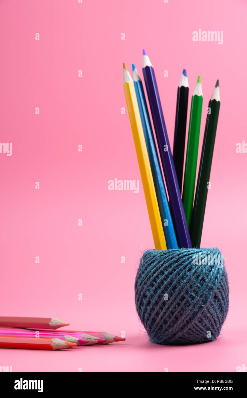 color pencils and string basket on red background Stock Photo - Alamy