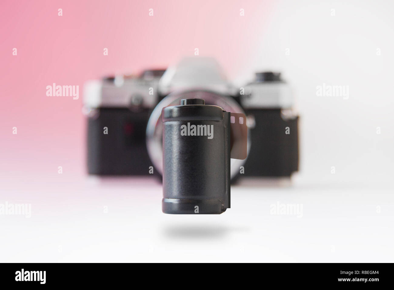 Soaring 35 mm Negative Film Canister on Blurry SLR Camera Back Stock ...